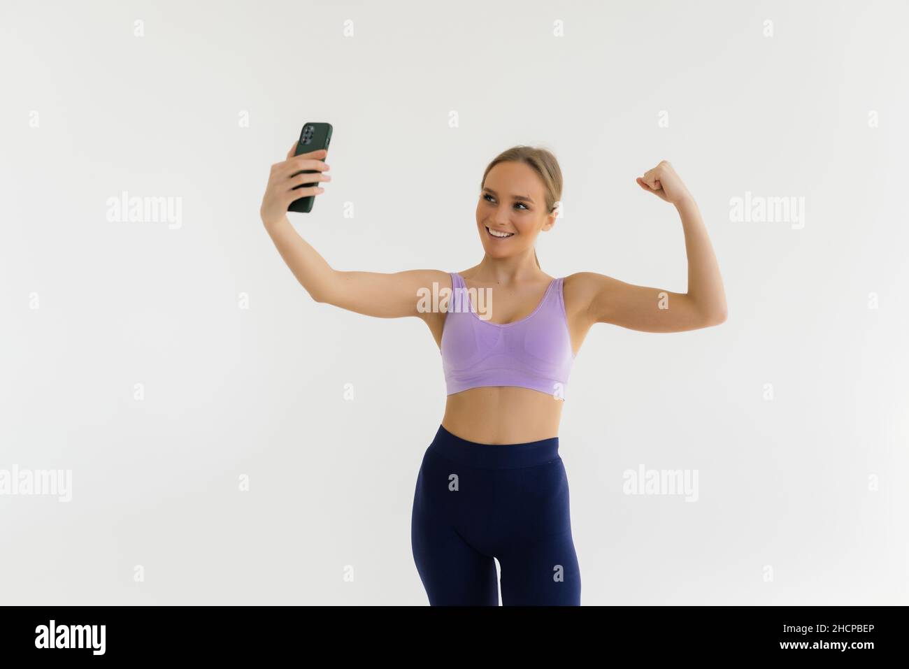 Young woman making video call and pointing gladly at camera of her ...