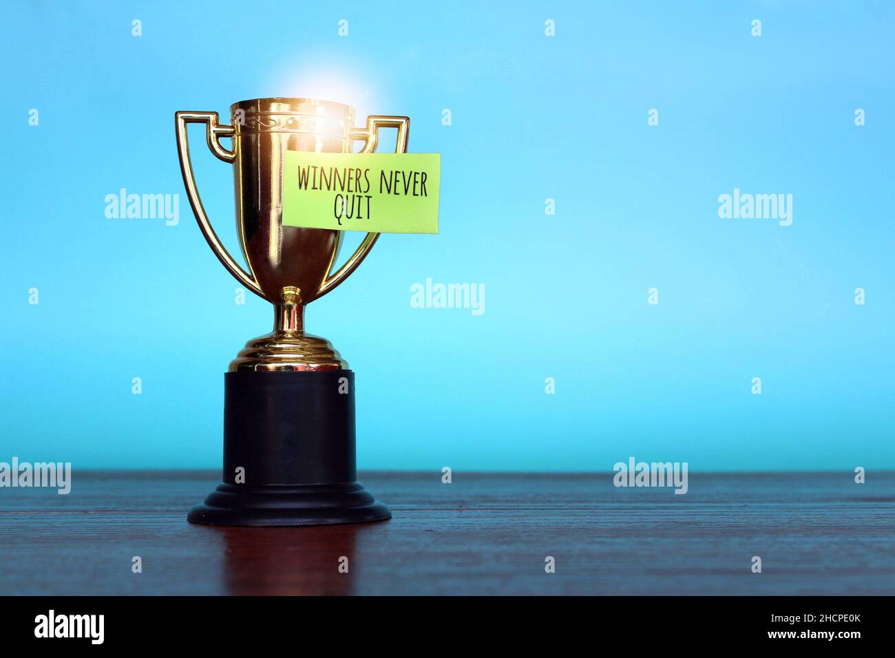 Close up image of gold cup trophy and sticky note with text WINNERS ...