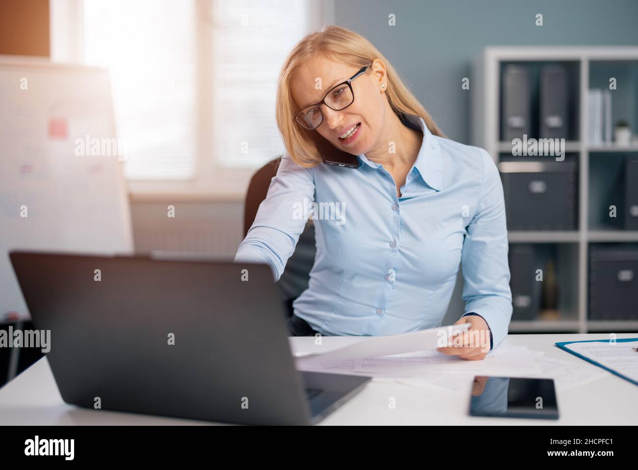 Multitasking of woman at office Stock Photo - Alamy