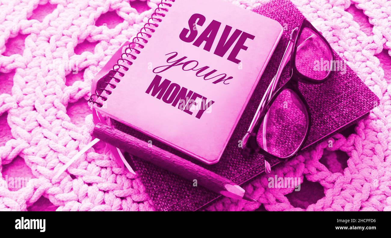 text Save Your Money on the cover of notebook, glasses and pen ...