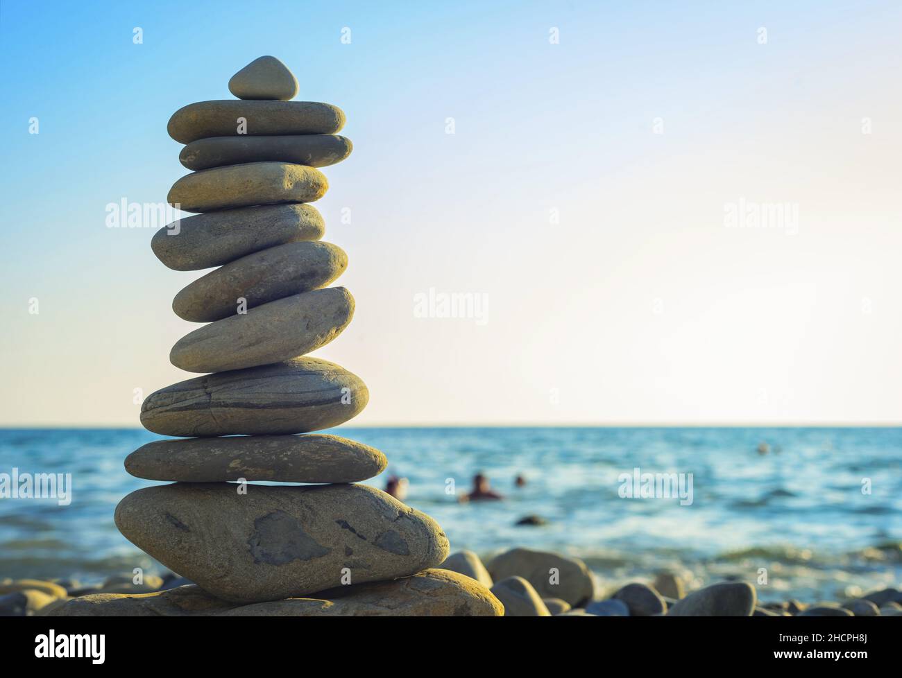 beach pebble stones pyramid on sea shore Stock Photo - Alamy