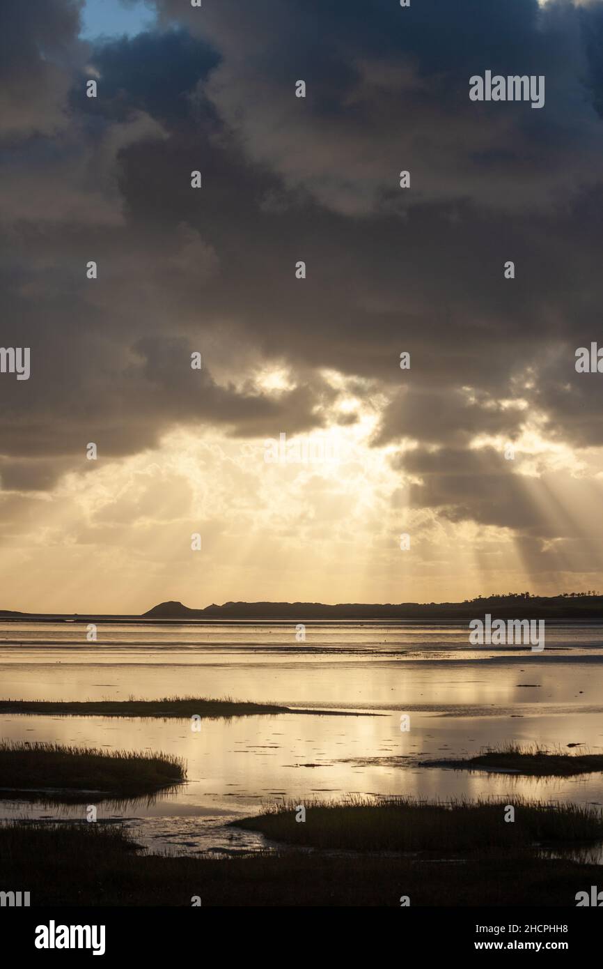 Shafts of sun ray light breaking through clouds at Malltraeth Anglesey ...