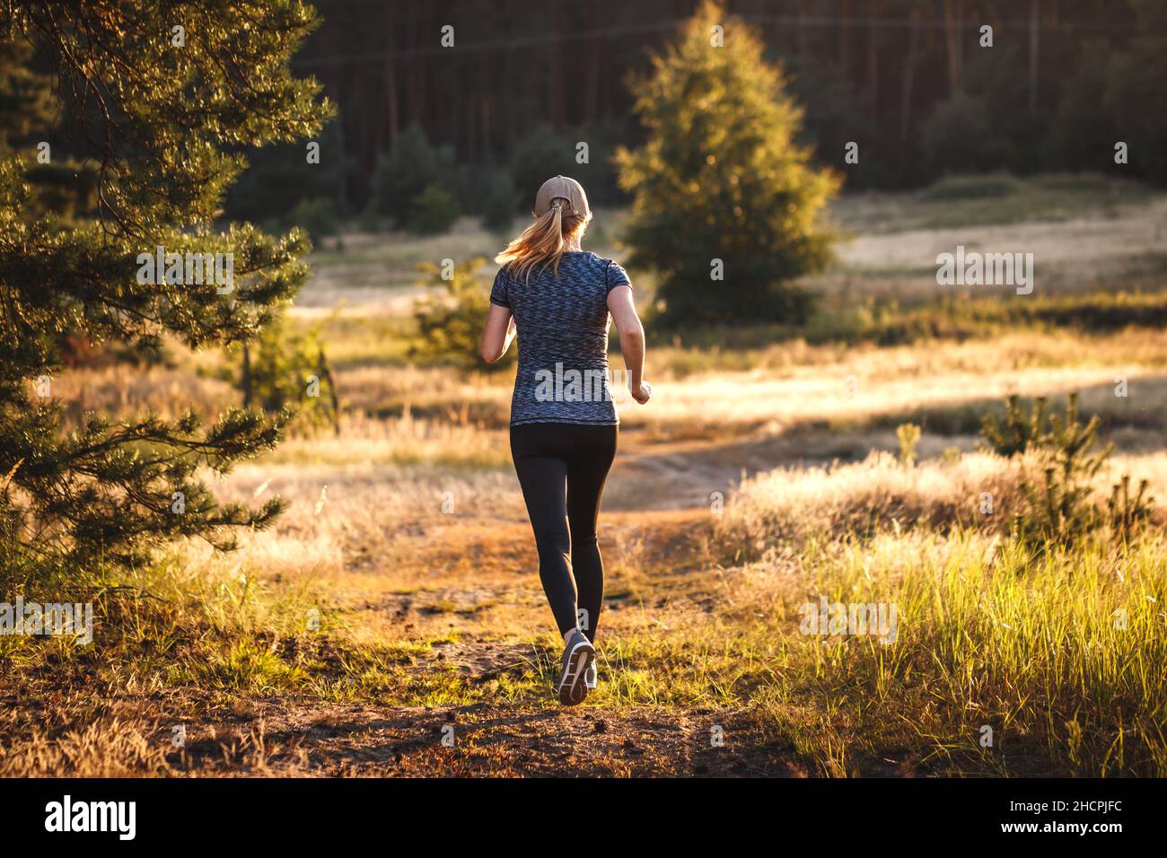 Woman running in nature during sunset. Female runner jogging outdoors ...