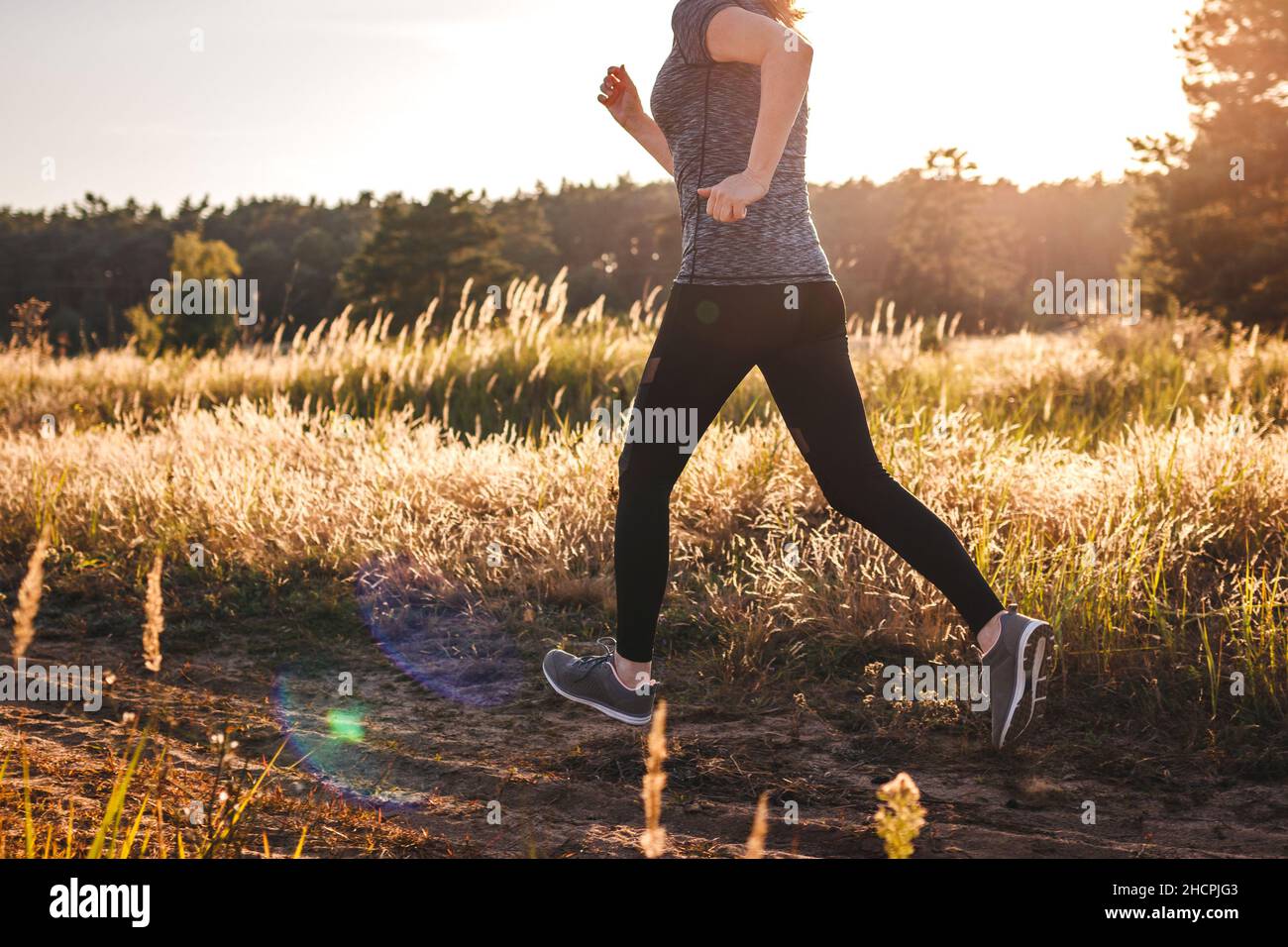 Woman running in nature during summer sunset. Female runner jogging ...