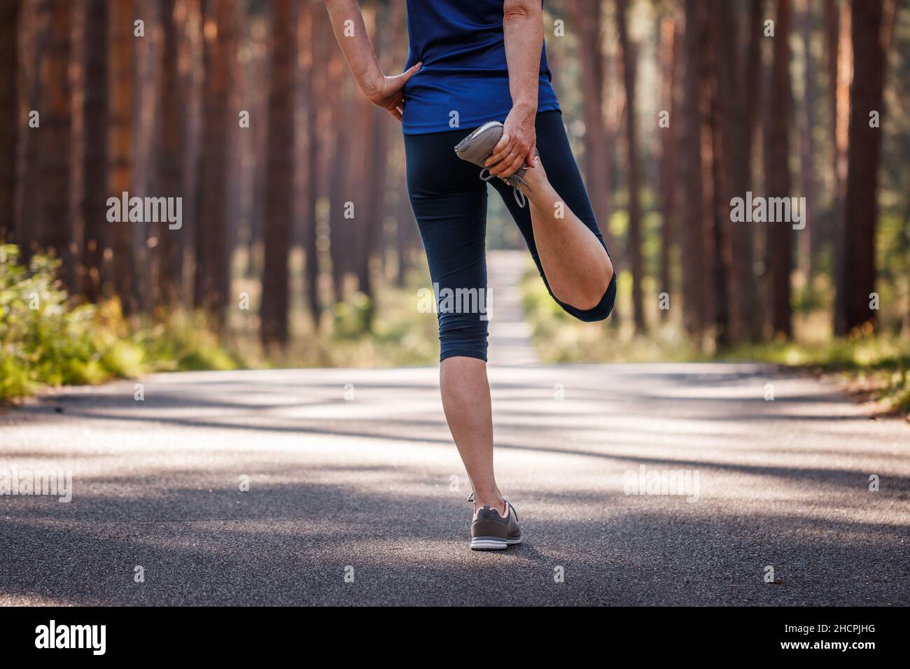 Warm up exercise before jogging. Sport training. Woman stretching ...