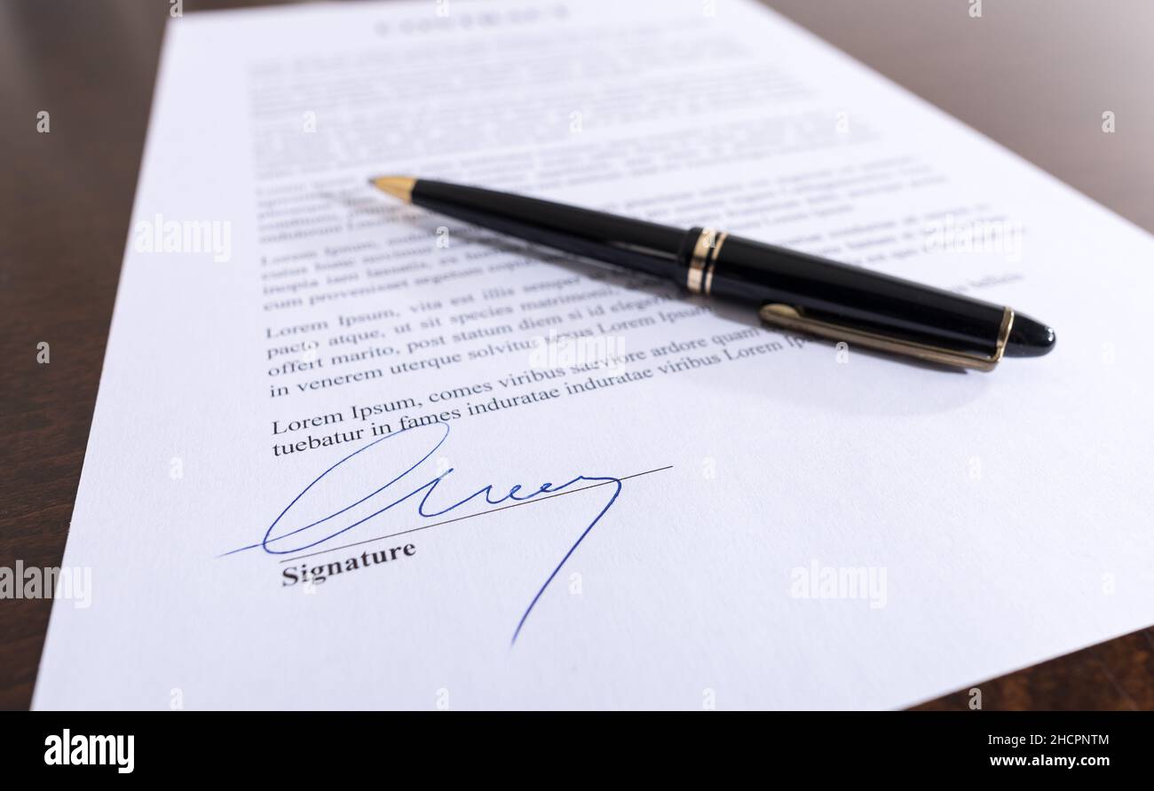 Pen placed on a signed contract Stock Photo - Alamy