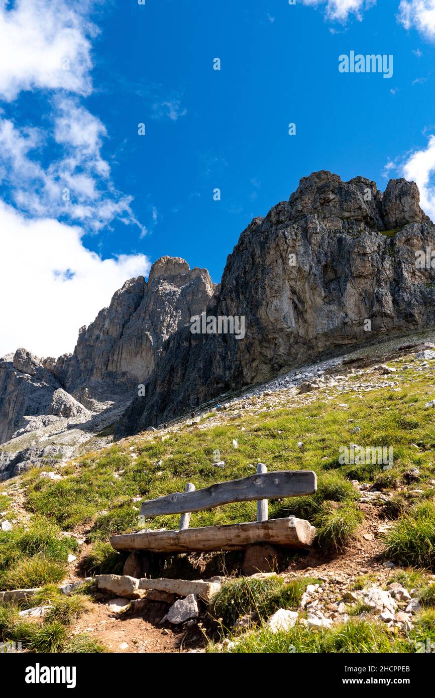 A vertical shot of two giant cliffs with a wooden bench at the bottom ...