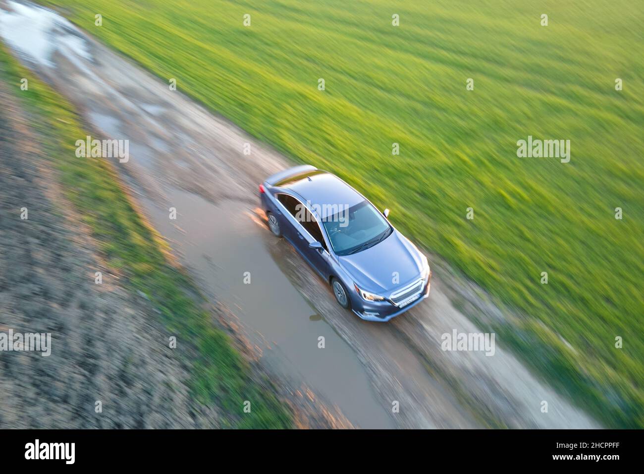 Aerial view of sedan car driving fast on dirt road at sunset. Traveling ...