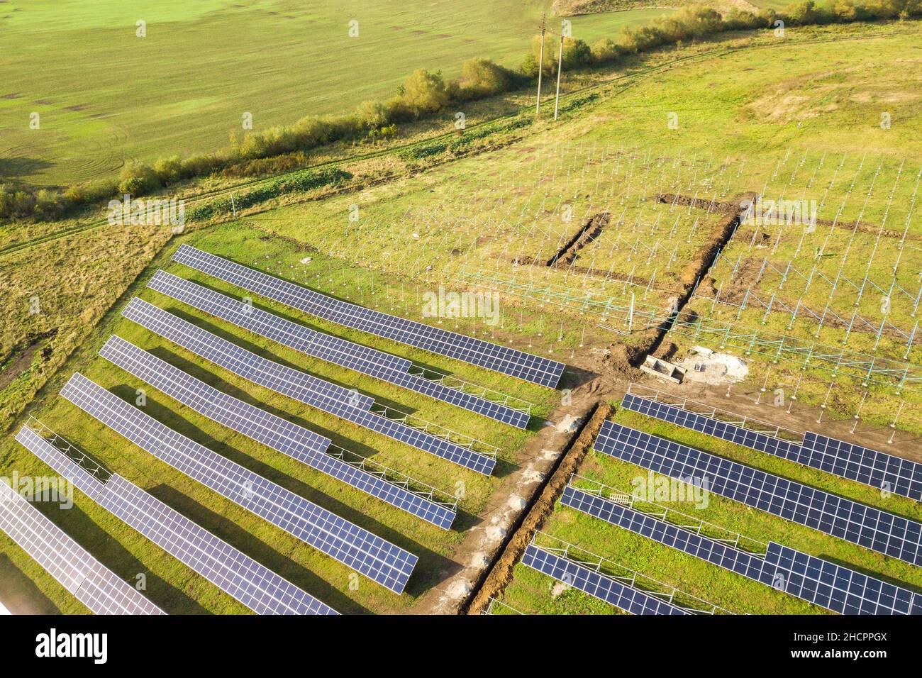 Aerial view of solar power plant under construction on green field ...