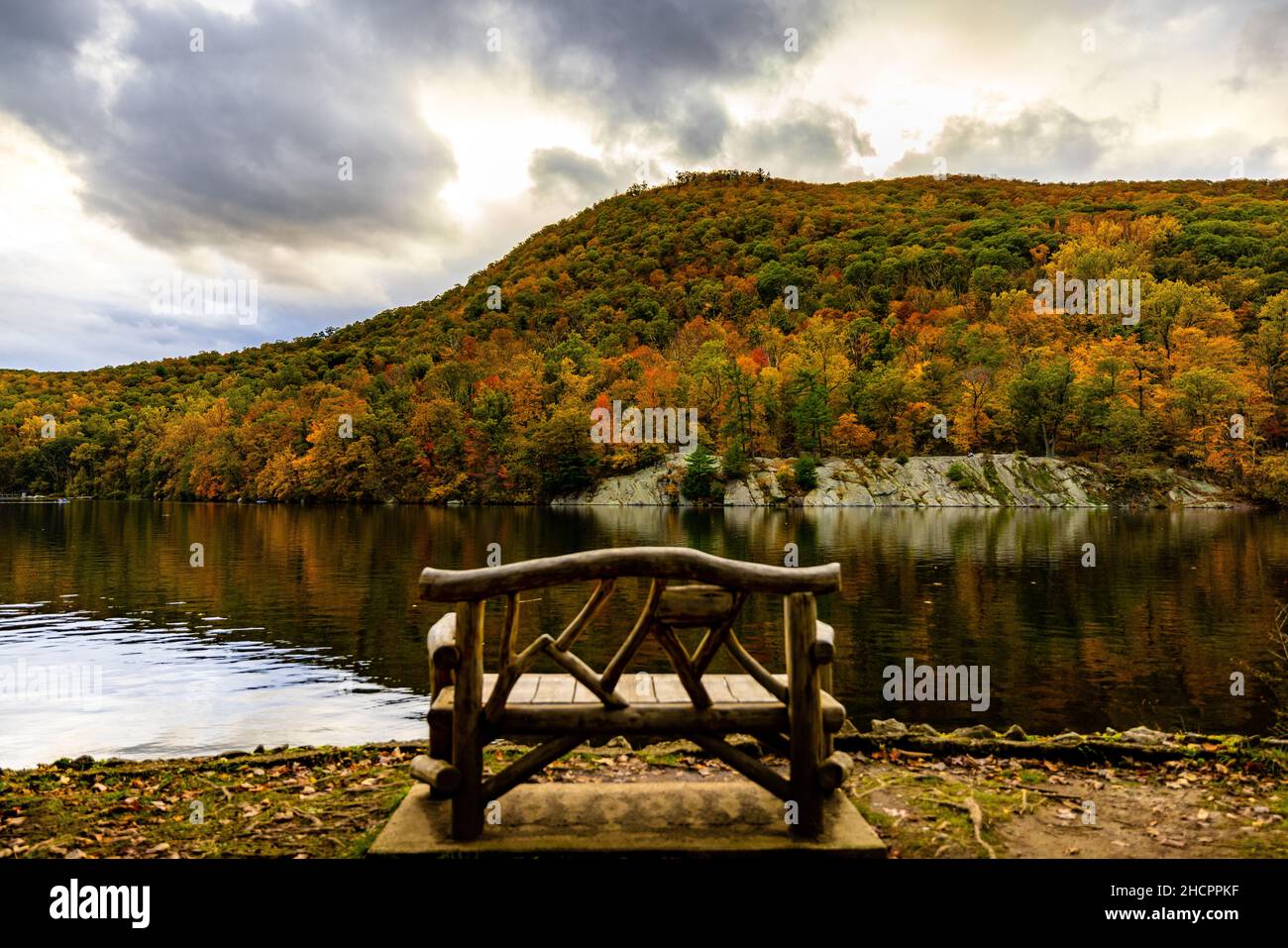 Wooden bench with the autumn view of Hessian Lake at Bear Mountain ...
