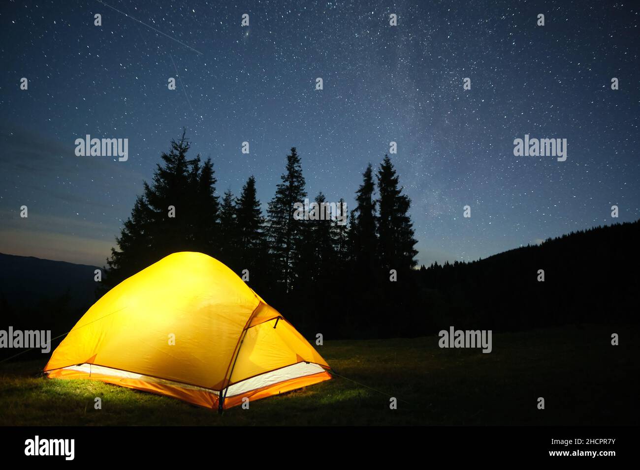 Bright illuminated tourist tent glowing on camping site in dark ...