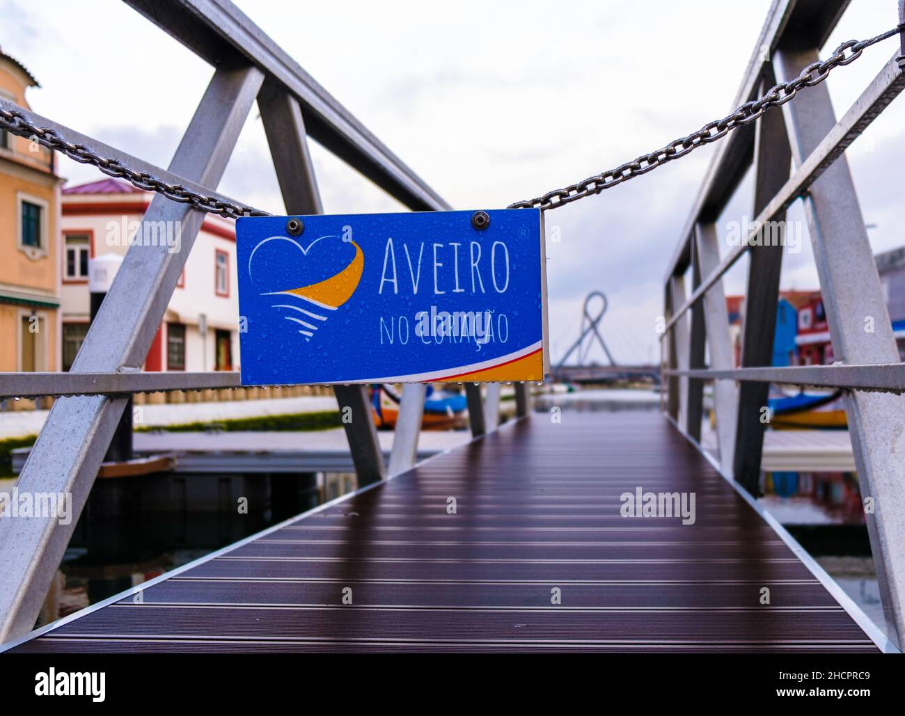 Selective focus shot of a hanging wooden sign on a metal pedestrian ...