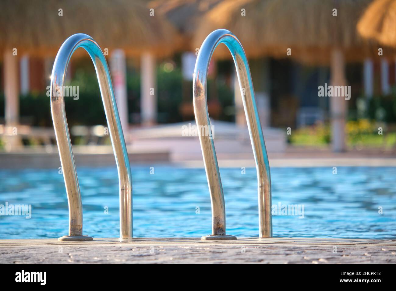 Close up of swimming pool stainless steel handrail descending into ...