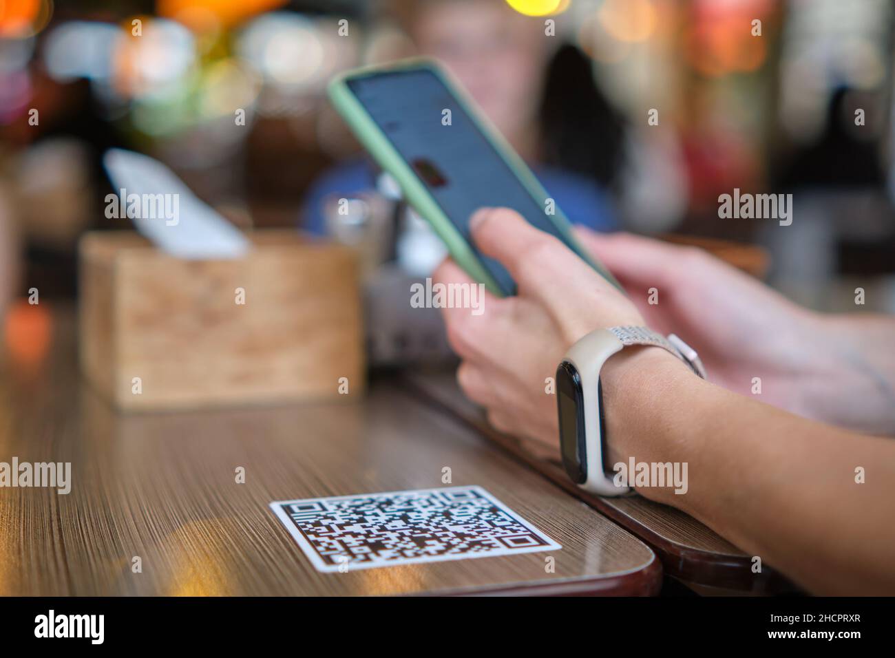 Closeup of guest hand ordering meal in restaurant while scanning qr ...