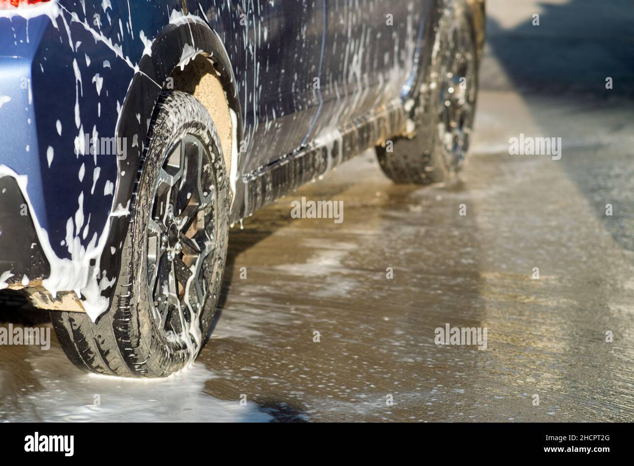 Closeup of male driver washing his car with contactless high pressure ...