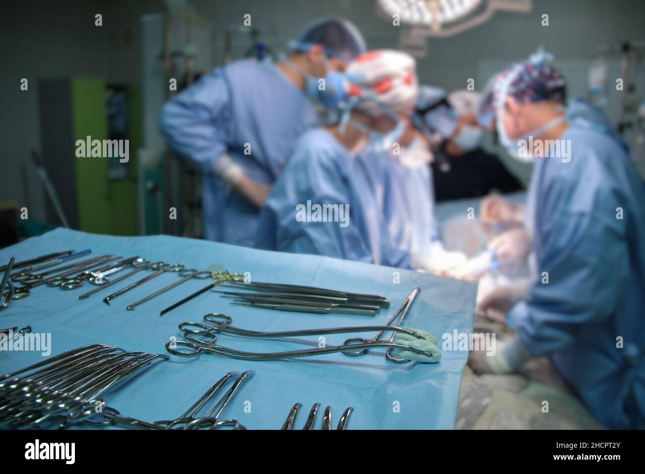 Closeup of surgical tools on table and team of surgery doctors ...