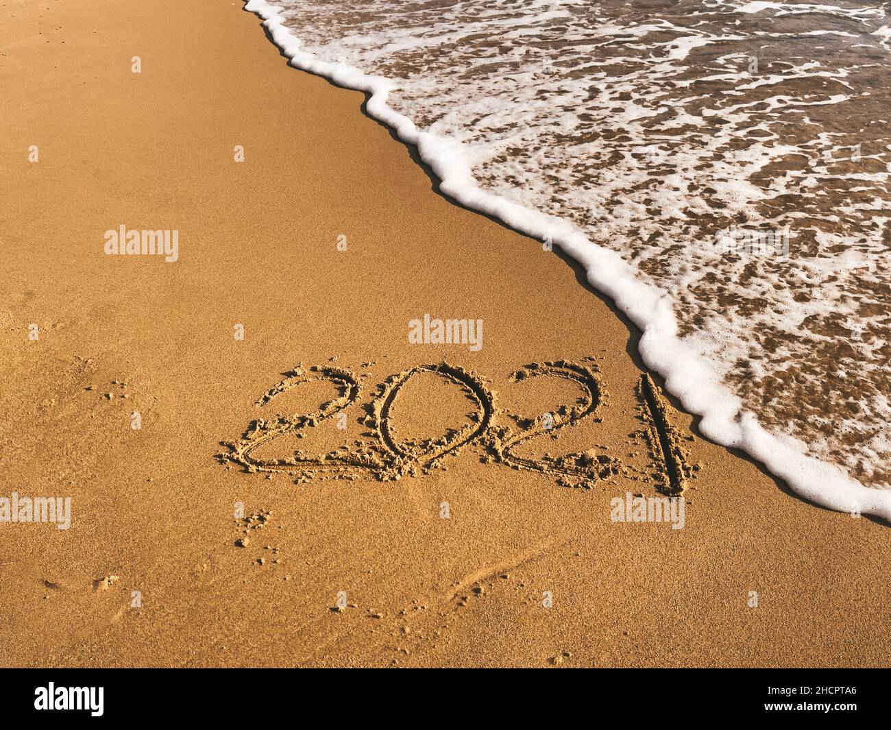The inscription 2021 on the golden sand at the beach Stock Photo - Alamy