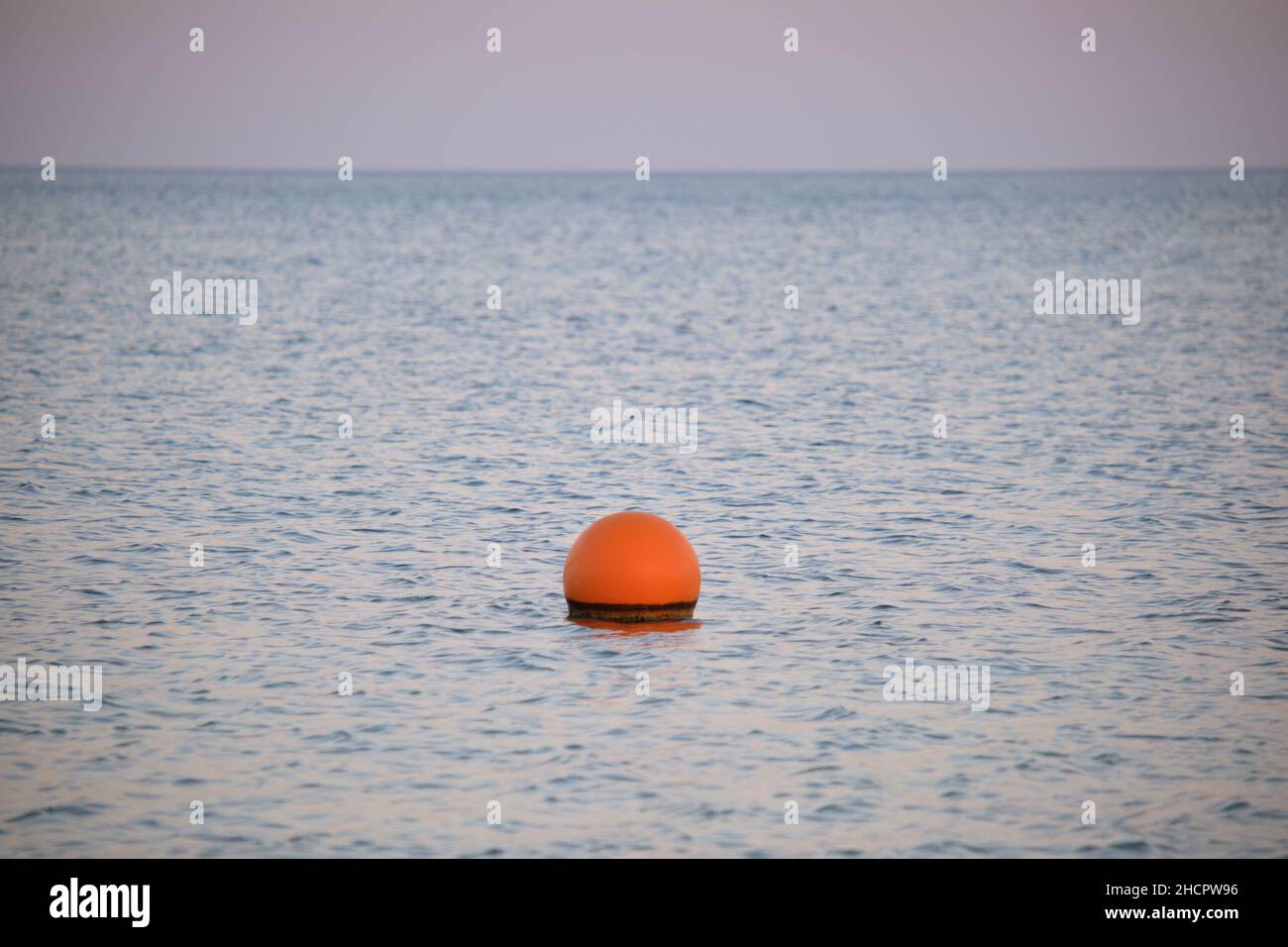 Orange buoy floating on sea surface waves. Human life safety concept ...