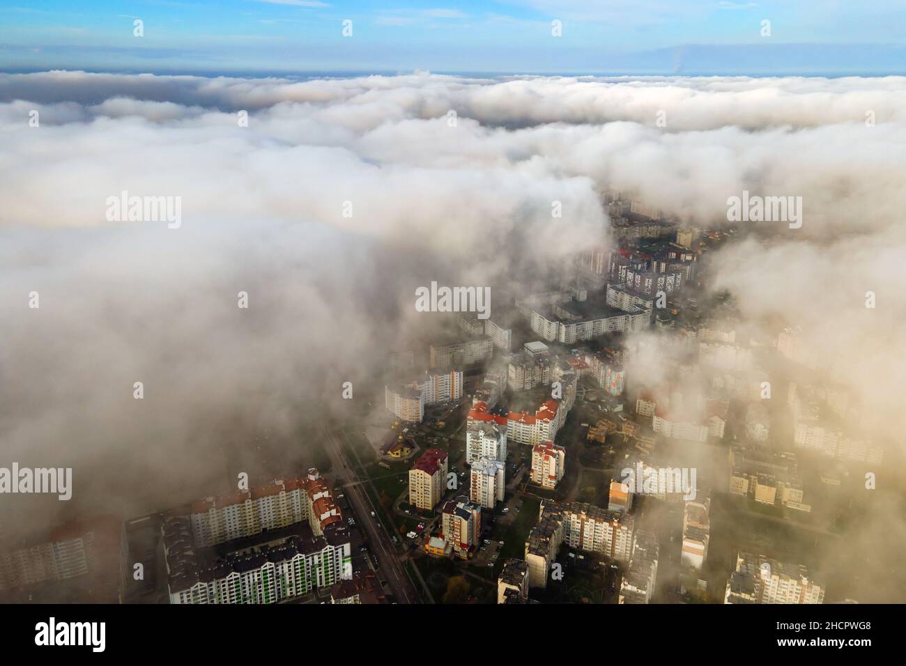 Top aerial view of fluffy white clouds over modern city with high rise ...