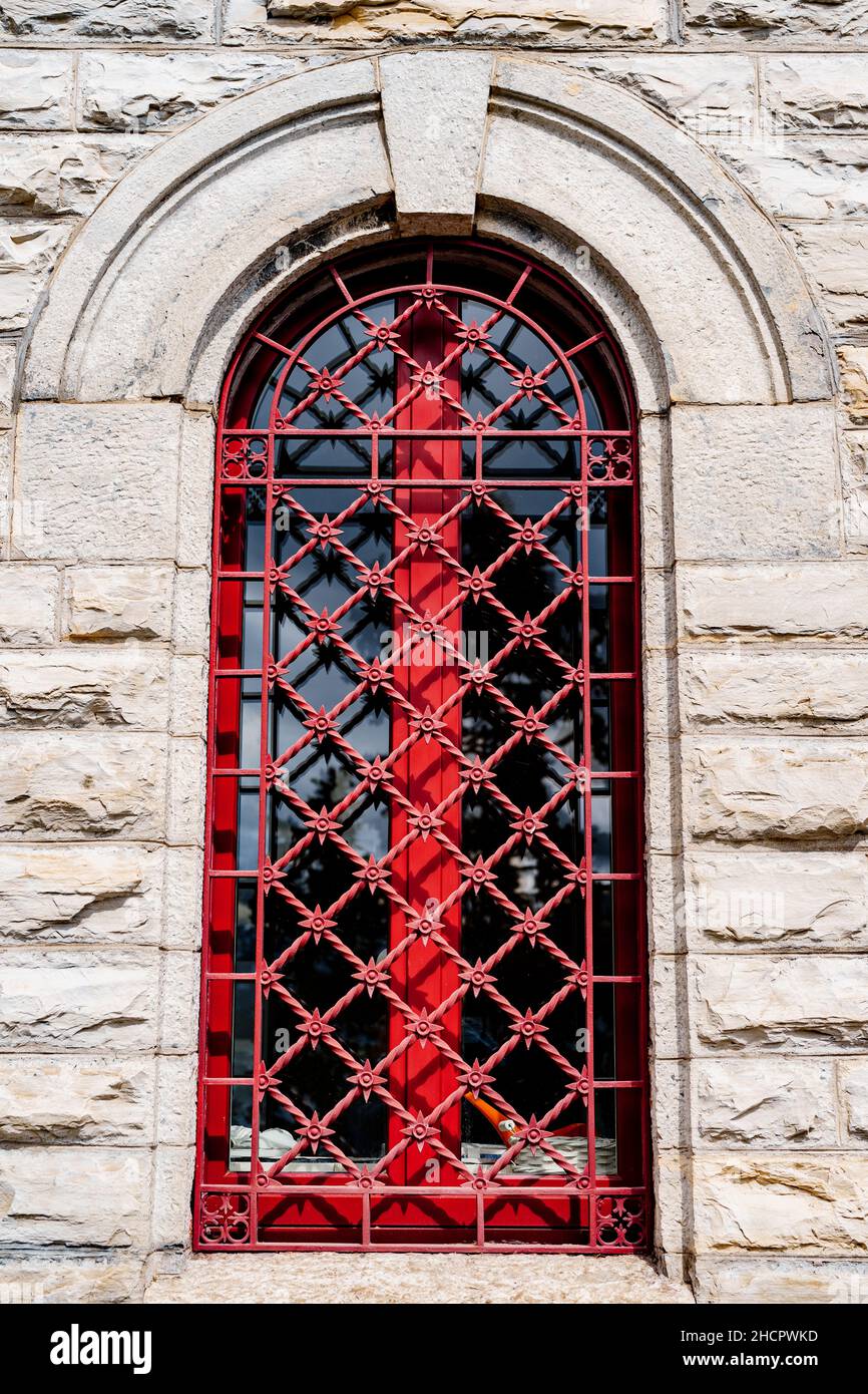 Red forged lattice on the arched window of an ancient building Stock ...