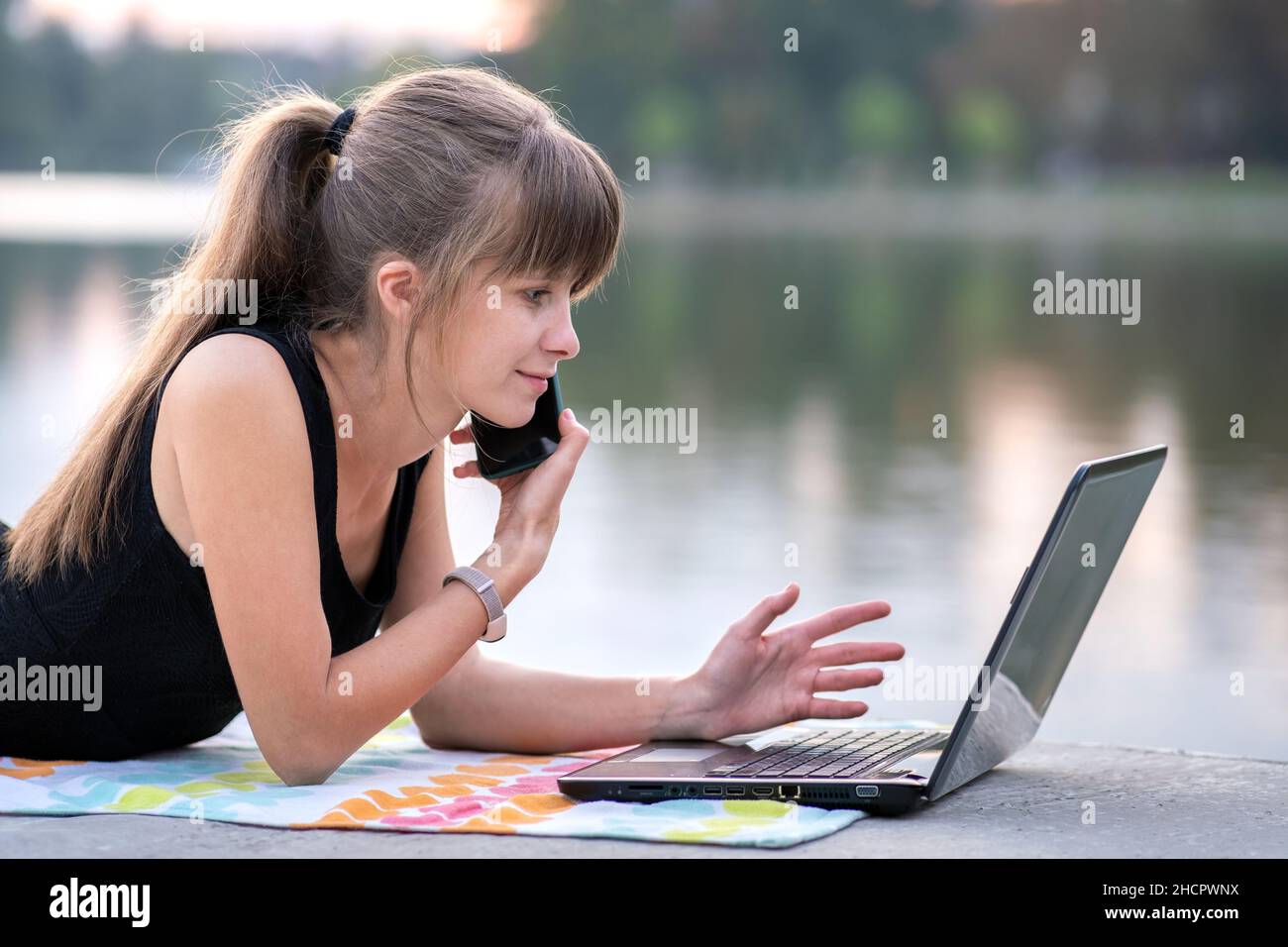 Young female office employee working behind laptop computer while ...