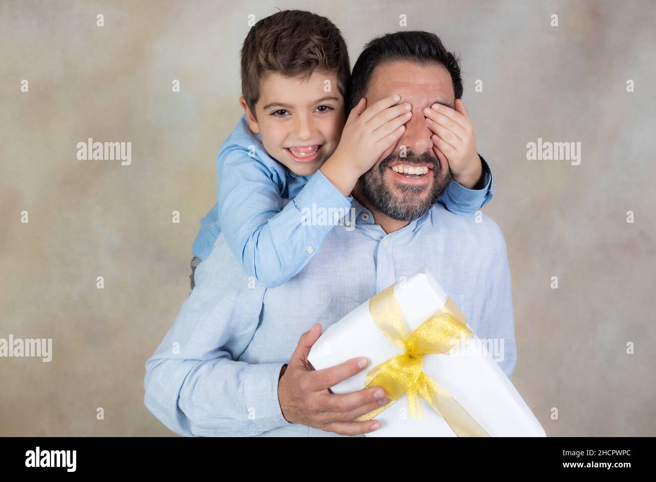Funny boy giving a gift to his father Stock Photo - Alamy