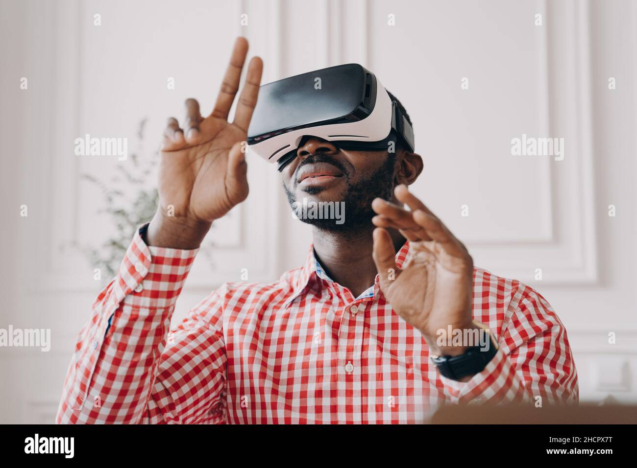 Black man in VR glasses experiencing 3D technology of augmented reality ...