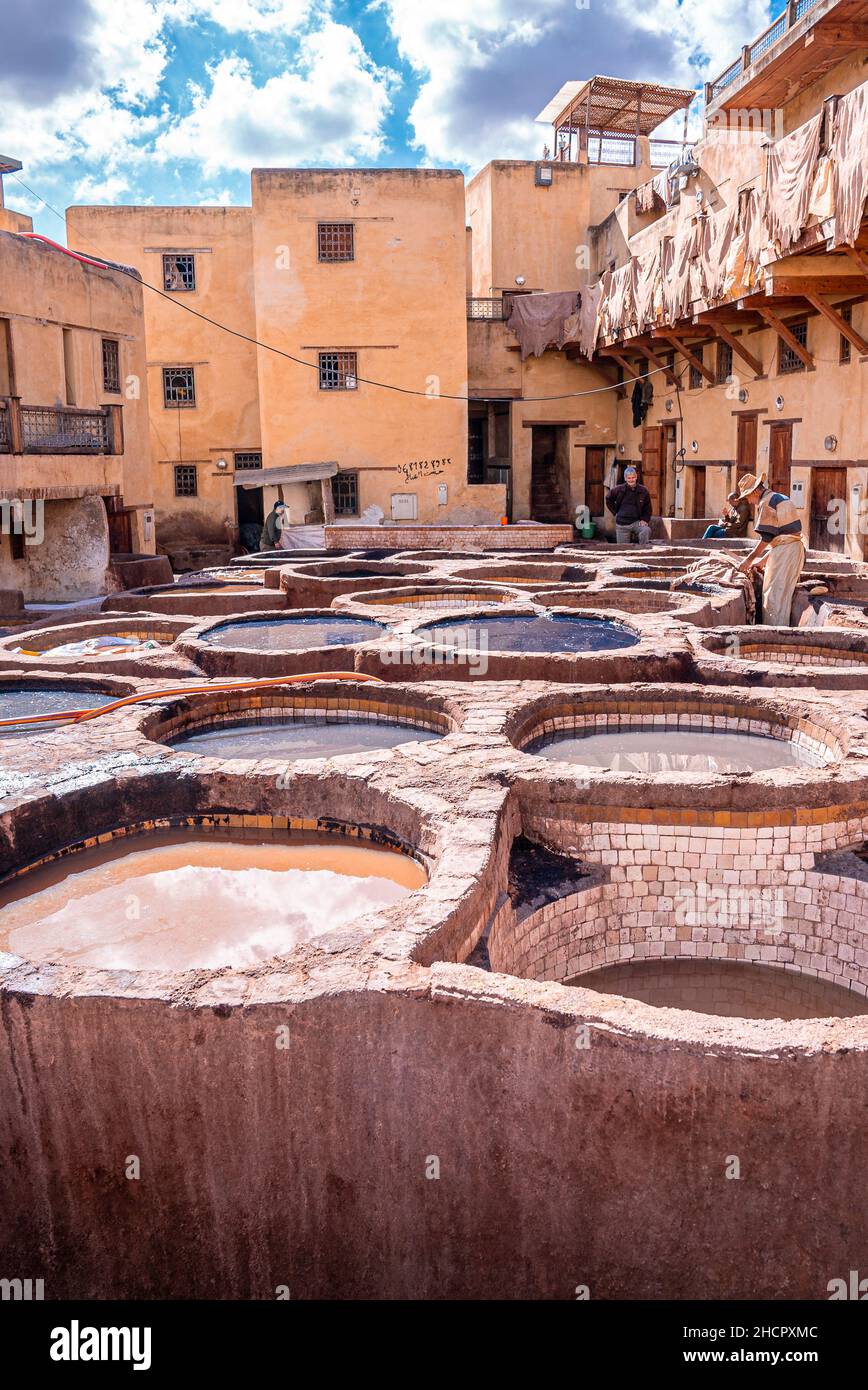 Dyed water fill in tanks in tannery against old residential building ...
