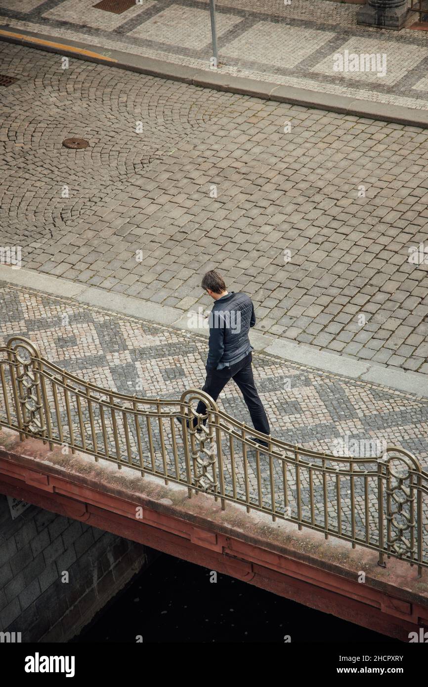 Vertical shot of a walking man on a bridge Stock Photo - Alamy