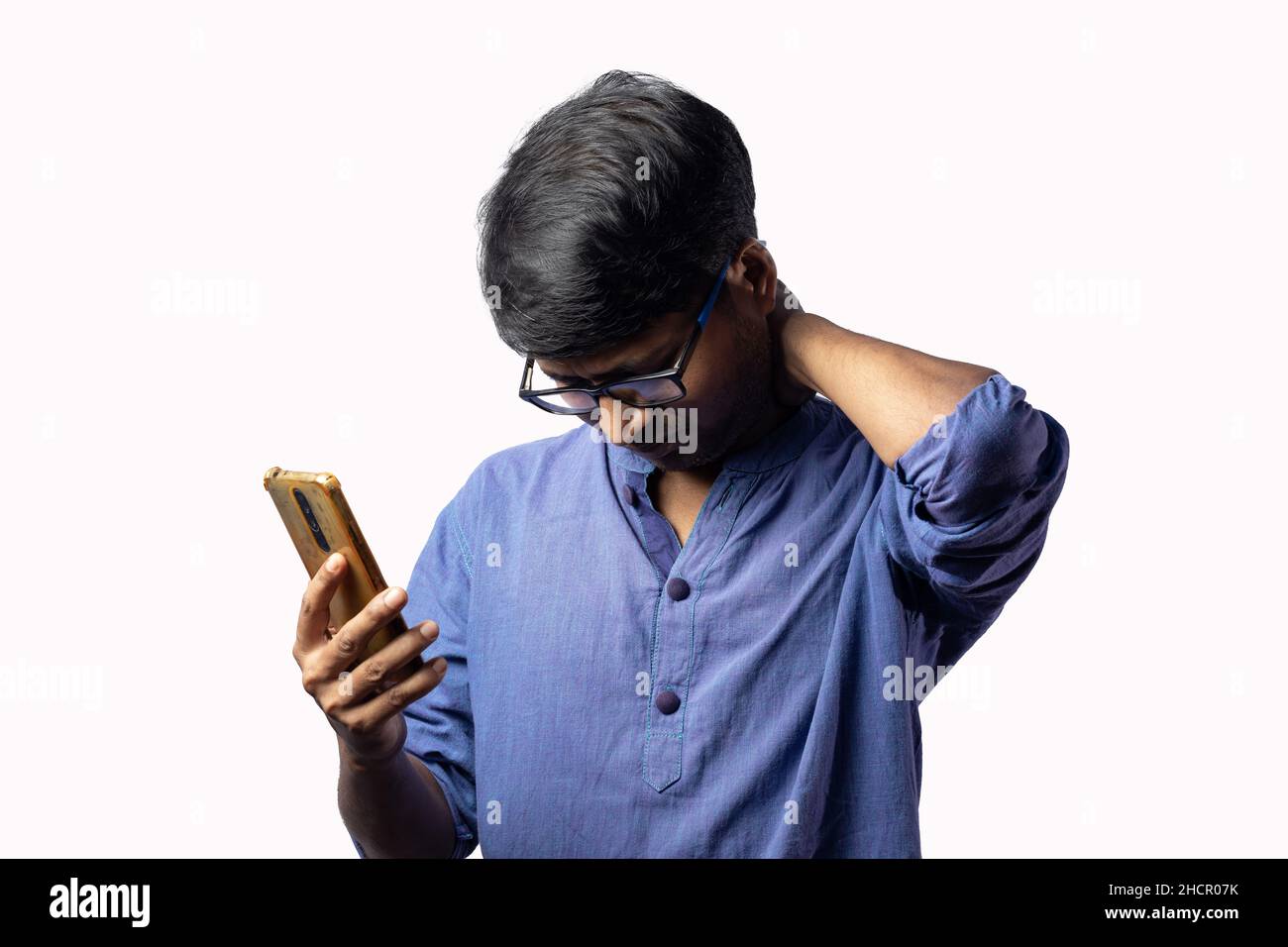 A young Indian male in blue dress facing neck pain problem using smart ...