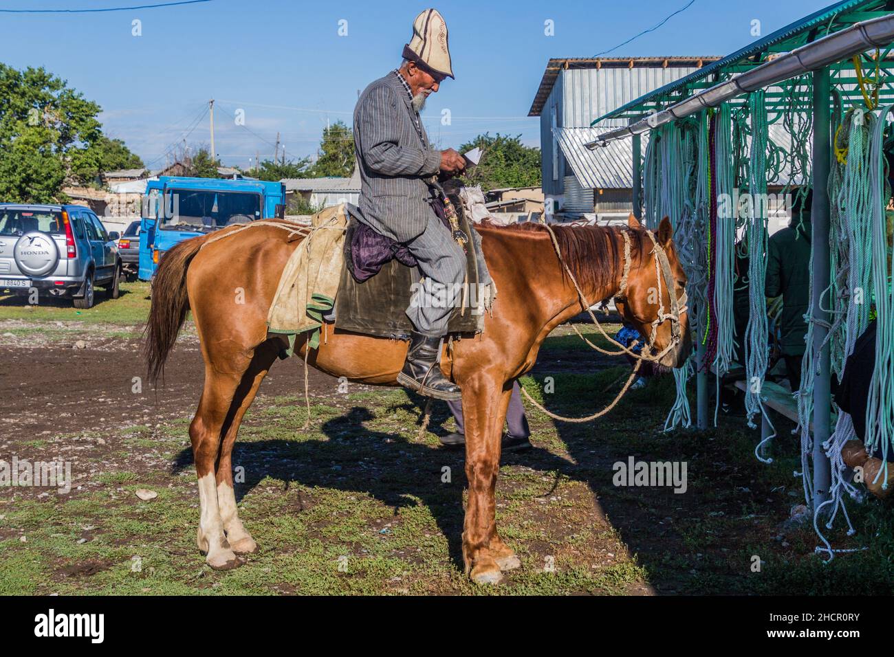 KARAKOL, KYRGYZSTAN - JULY 15, 2018: Local man riding a horse at the ...