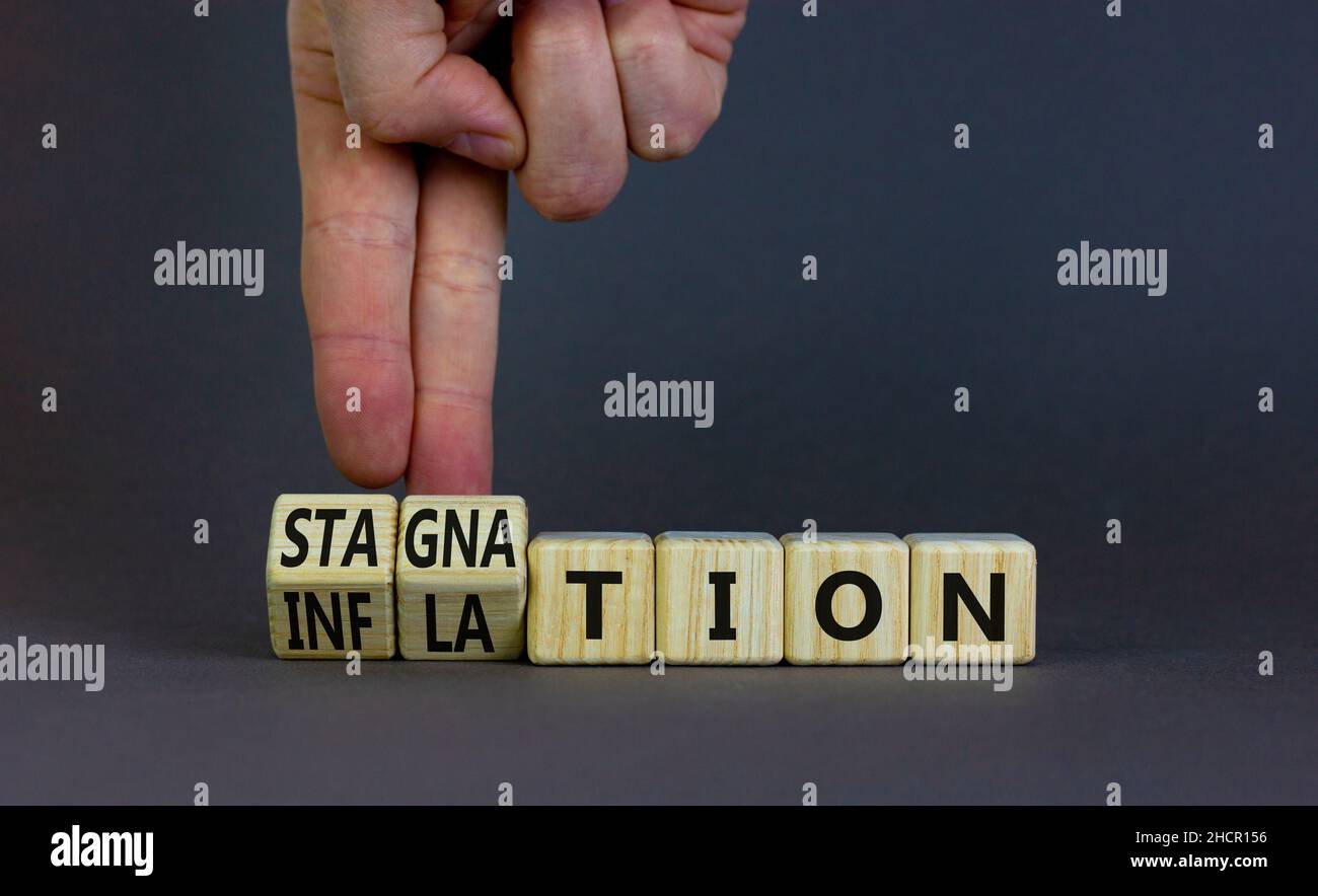 Inflation and stagnation symbol. Businessman turns cubes, changes the ...
