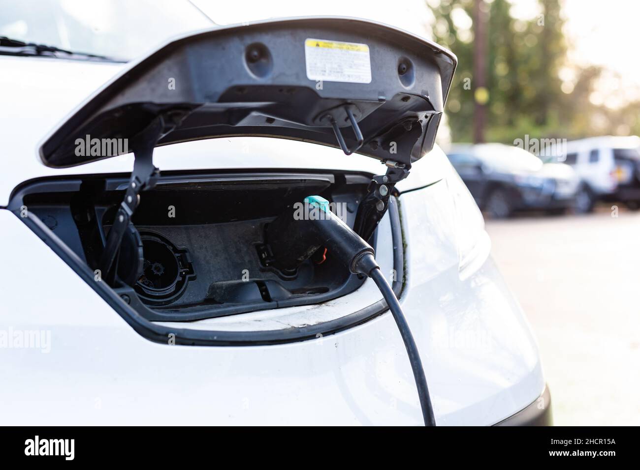 Electric car charging at plug in charge station in a public car park in ...