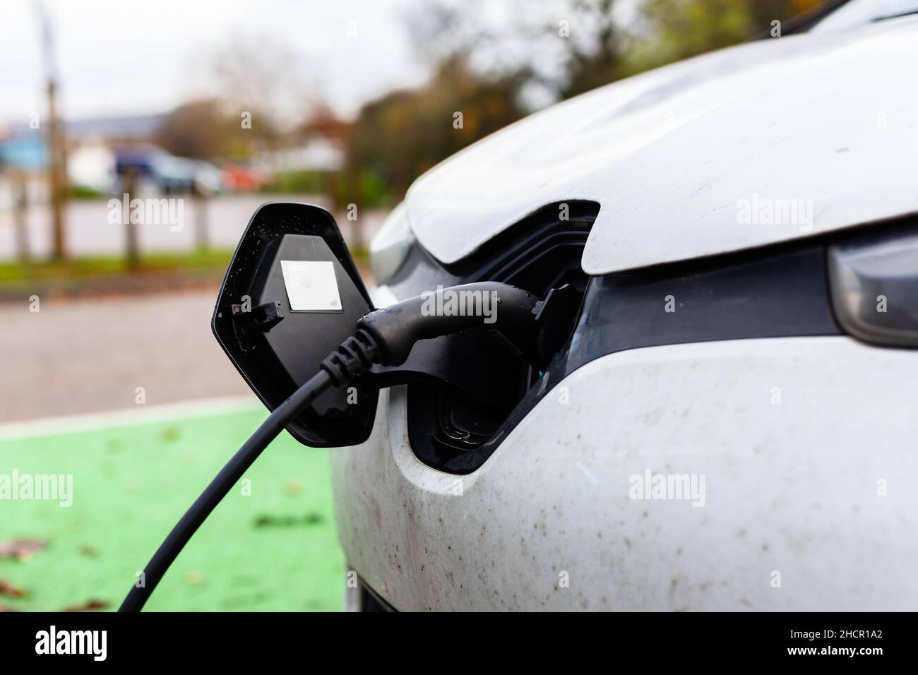 Electric car charging at plug in charge station in a public car park in ...