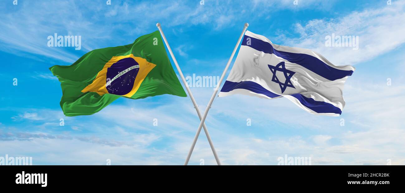 crossed national flags of Brazil and Israel flag waving in the wind at ...