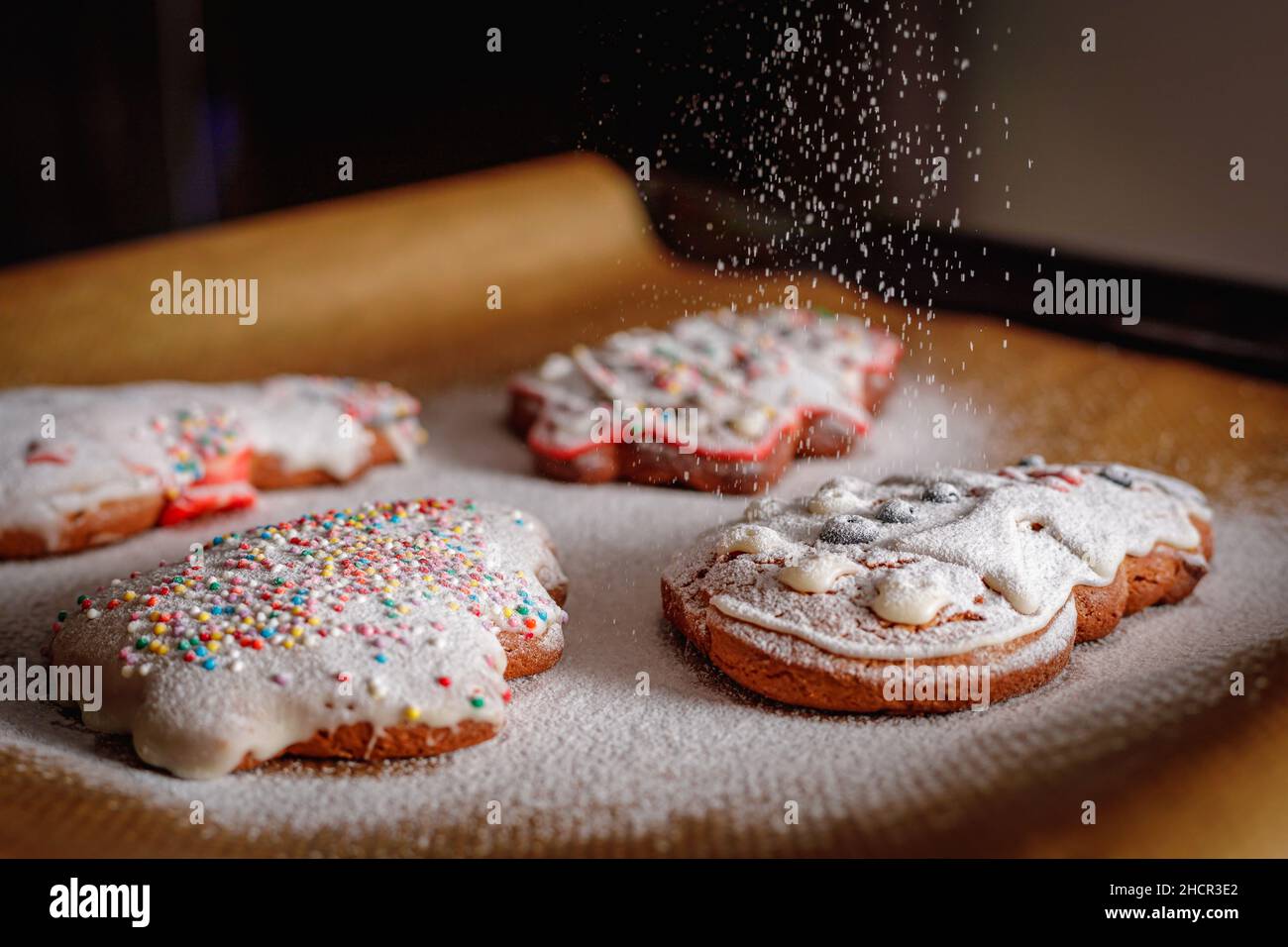 Sprinkle icing sugar over the Christmas cookies Stock Photo - Alamy