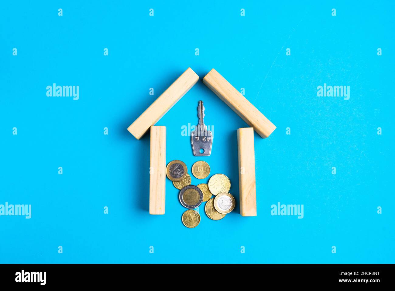 Wooden toy house with keys on a blue. Empty space to put text or ...