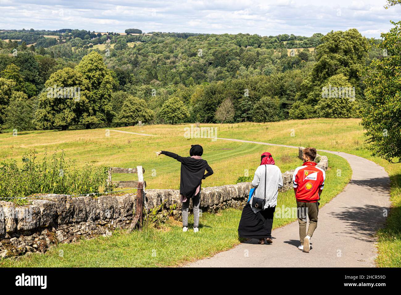 Walkers taking a stroll on a public footpath on the Miserden Park ...