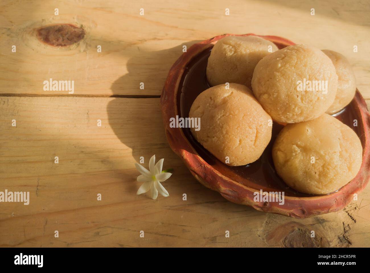 nolen gur rosogolla or rasgulla served on plate. brown spongy bengali ...