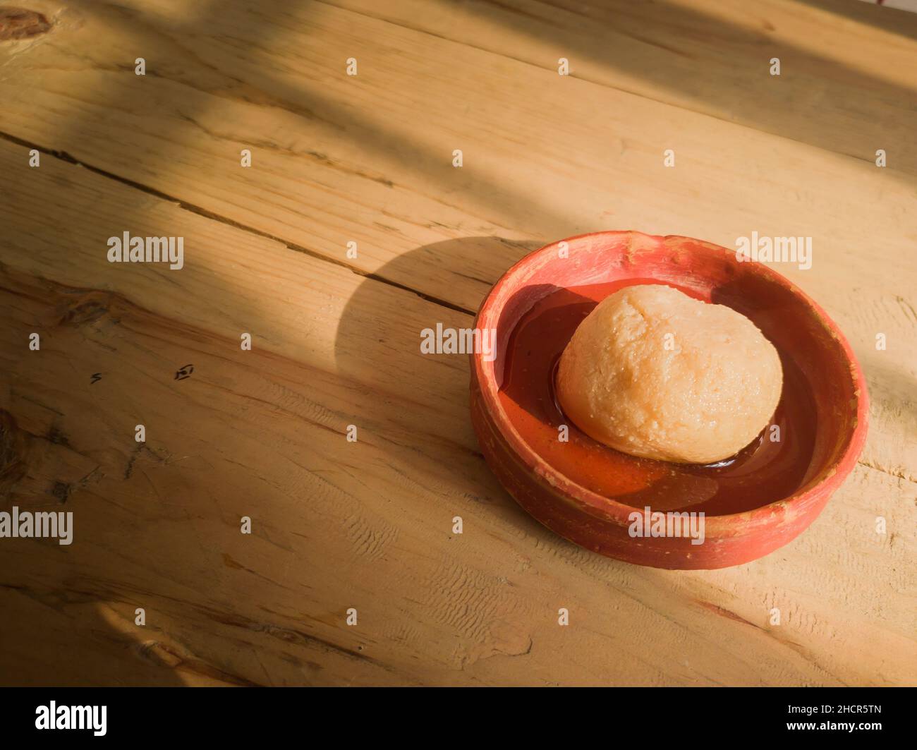 nolen gur rosogolla or rasgulla served on plate. brown spongy bengali ...