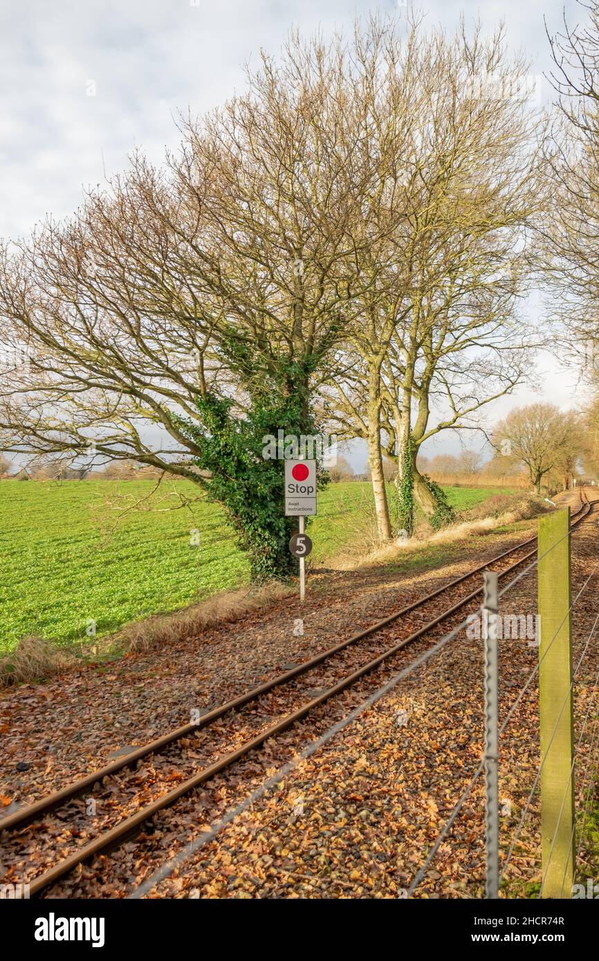 A train stop sign on the side of the railway tracks of the Bure Valley ...