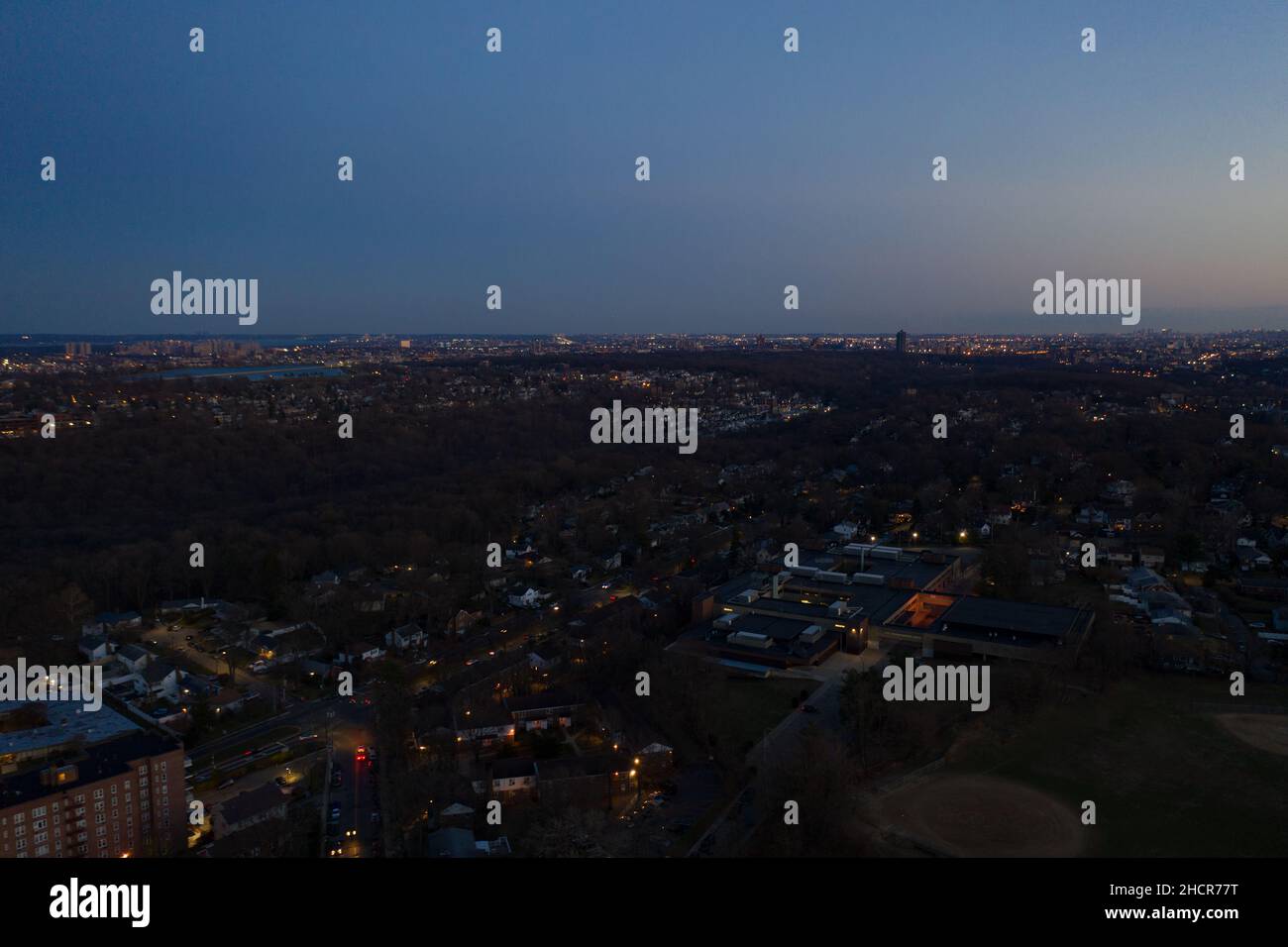 Bird's eye view of a city with greenery and city lights at dusk Stock ...
