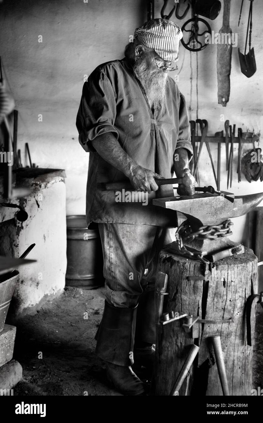A blacksmith demonstrates his trade in the blacksmith shop at El Rancho ...