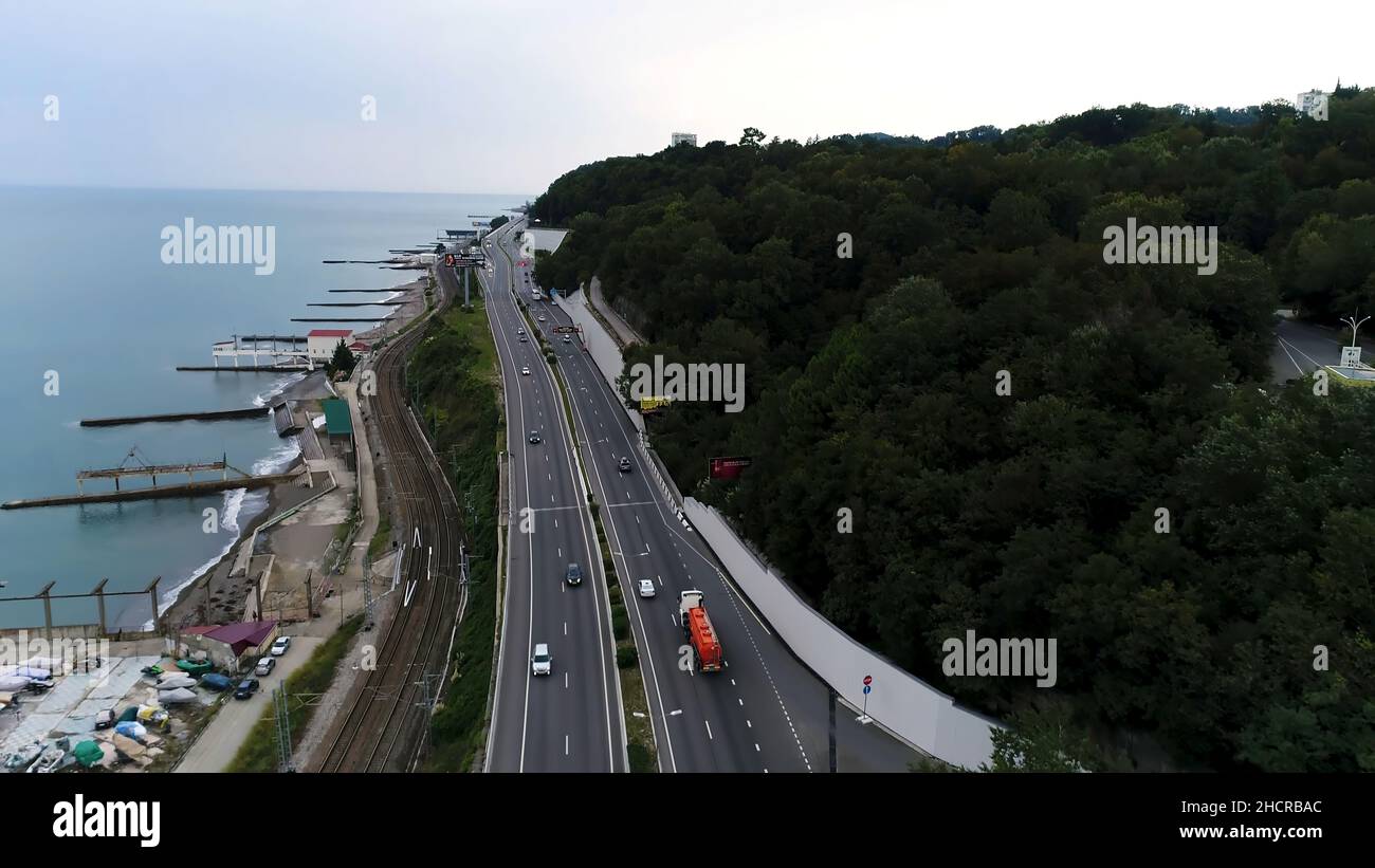 Aerial view of the road with moving cars and a truck along the mountain ...