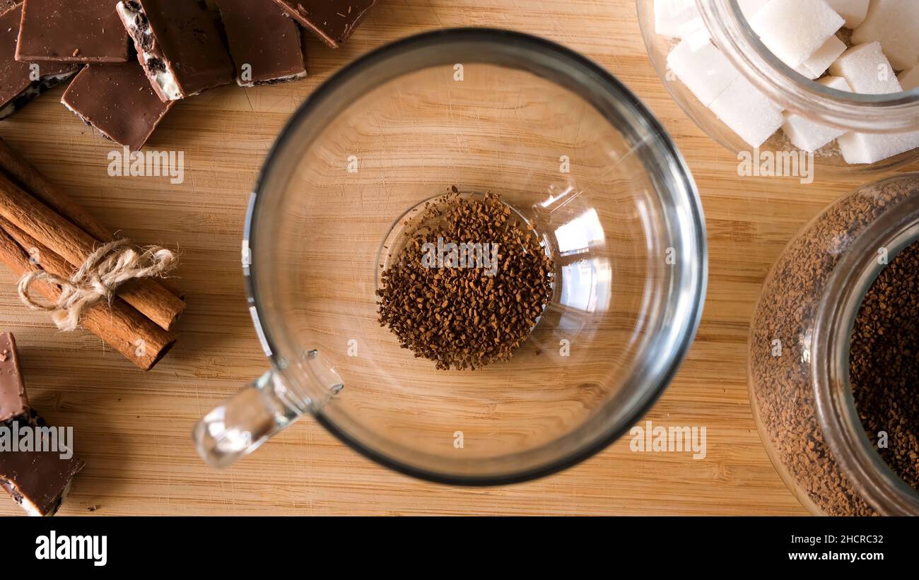 Top view of instant coffee preparation process. Putting coffee, sugar ...