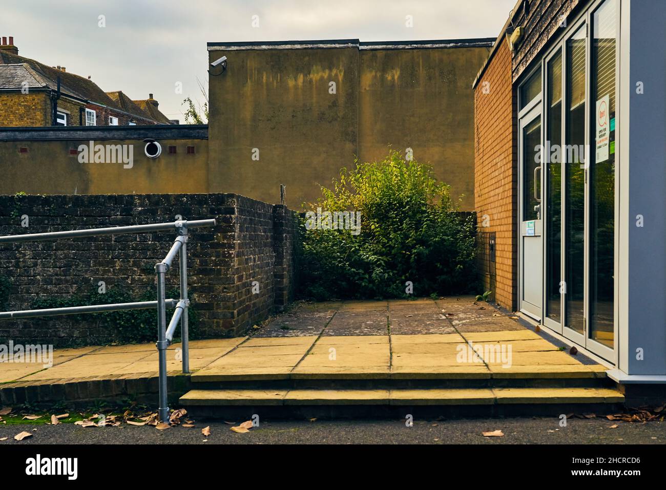 Street view from a terrace of an entrance of a building with bush ...