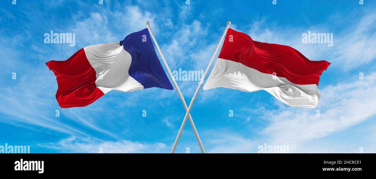 crossed national flags of France and Monaco flag waving in the wind at ...