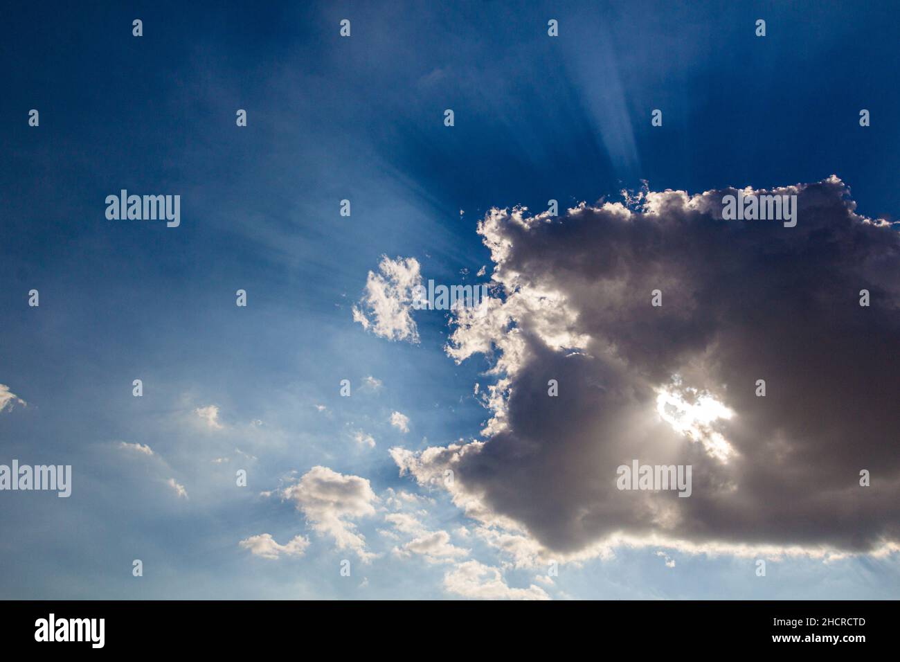 Rays of sun behind a cloud Stock Photo - Alamy