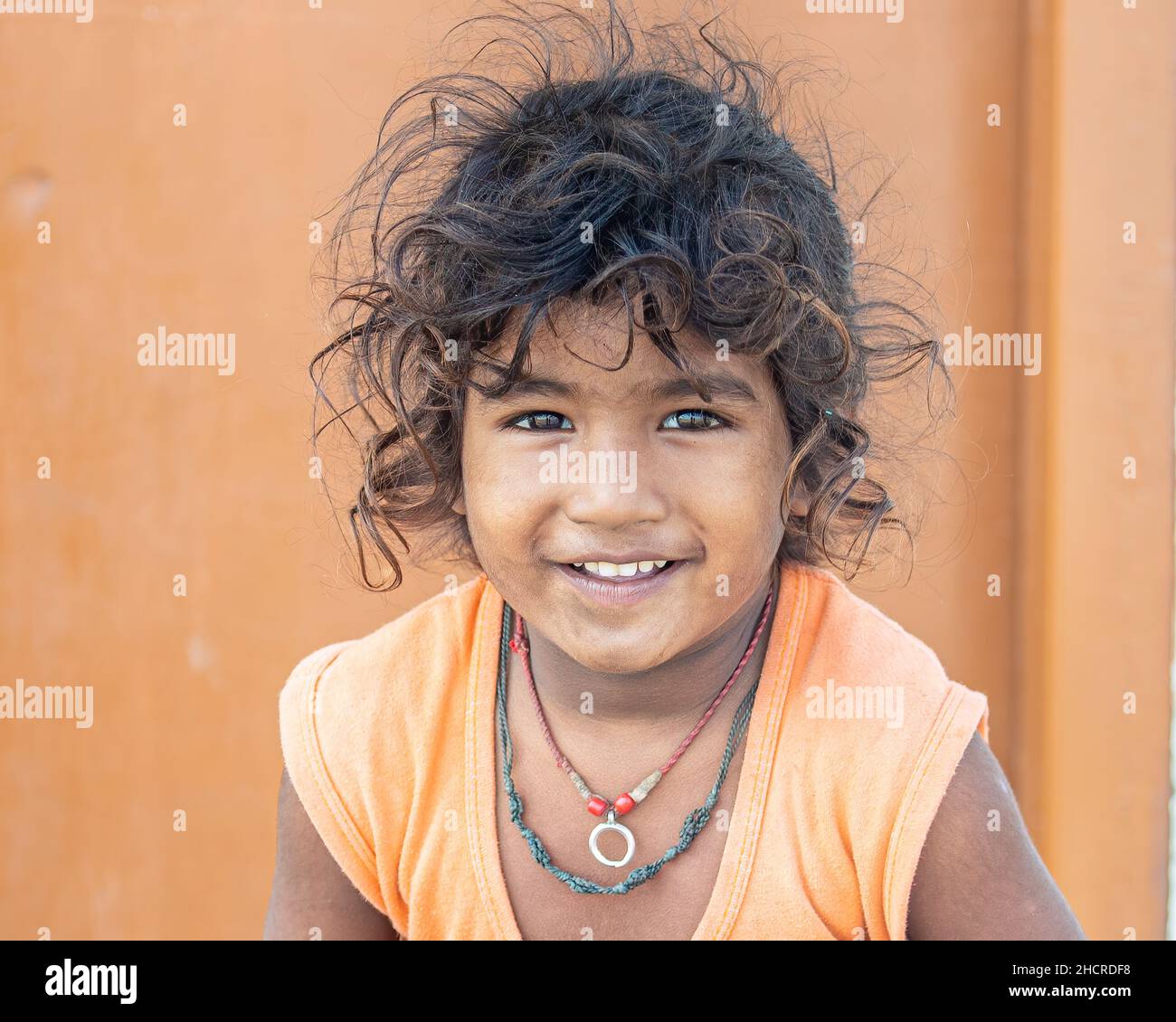 A girl with innocent smile and curly hair Stock Photo - Alamy