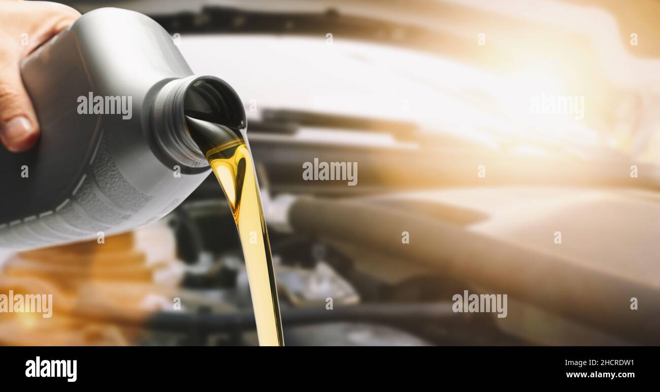 Pouring oil to car engine, Fresh oil poured during an oil change to a ...